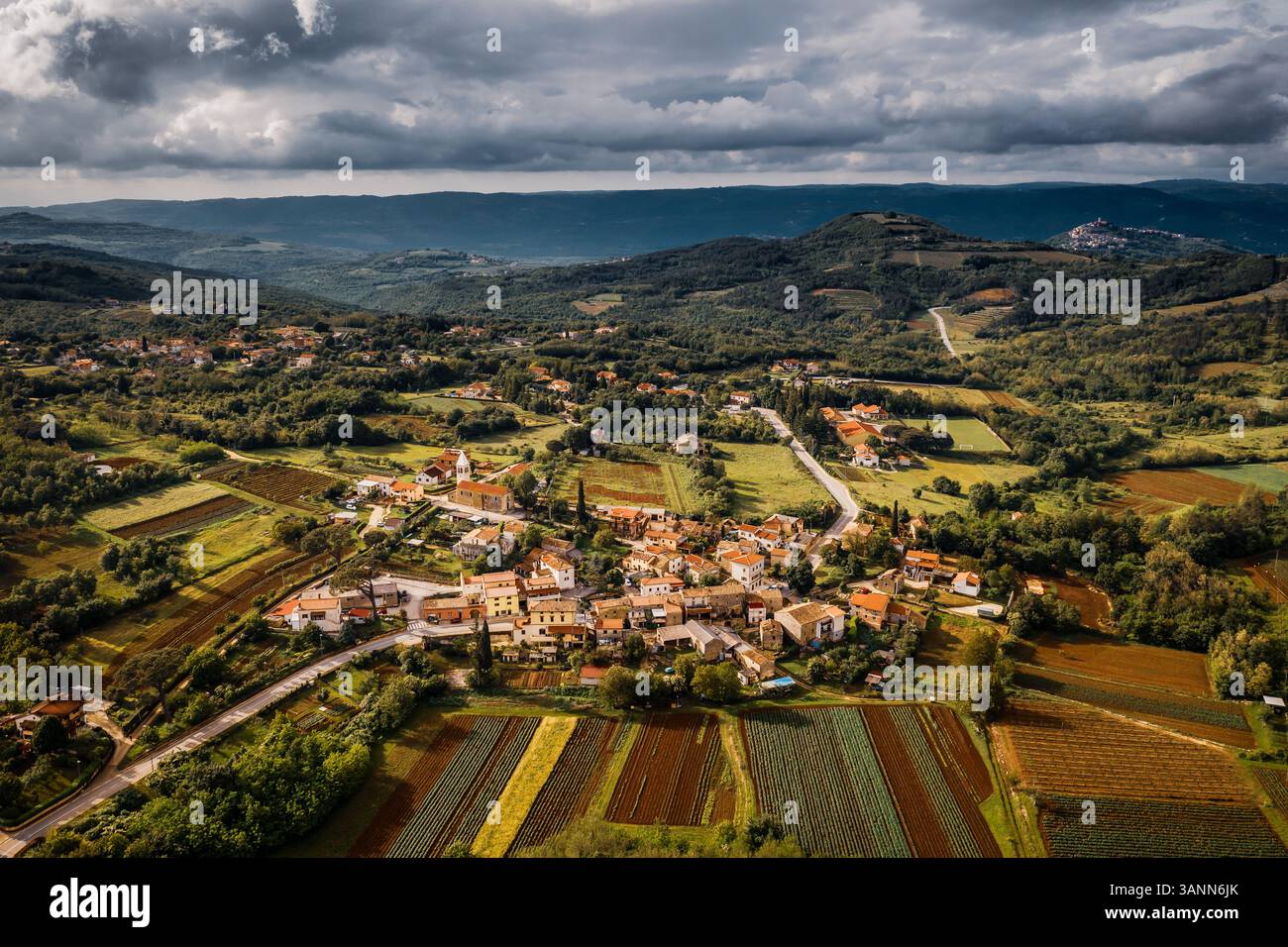 Aerial view of a village with mountains in the background on cloudy day ...