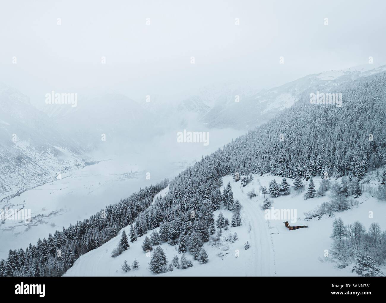 Aerial view of a small hut surrounded by snow-covered mountains and ...