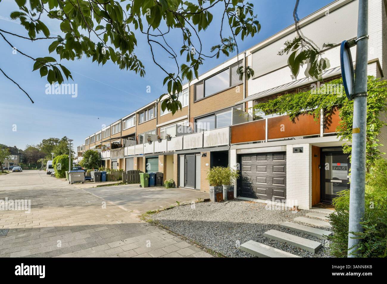 A street view showcasing modern residential buildings with greenery and ...