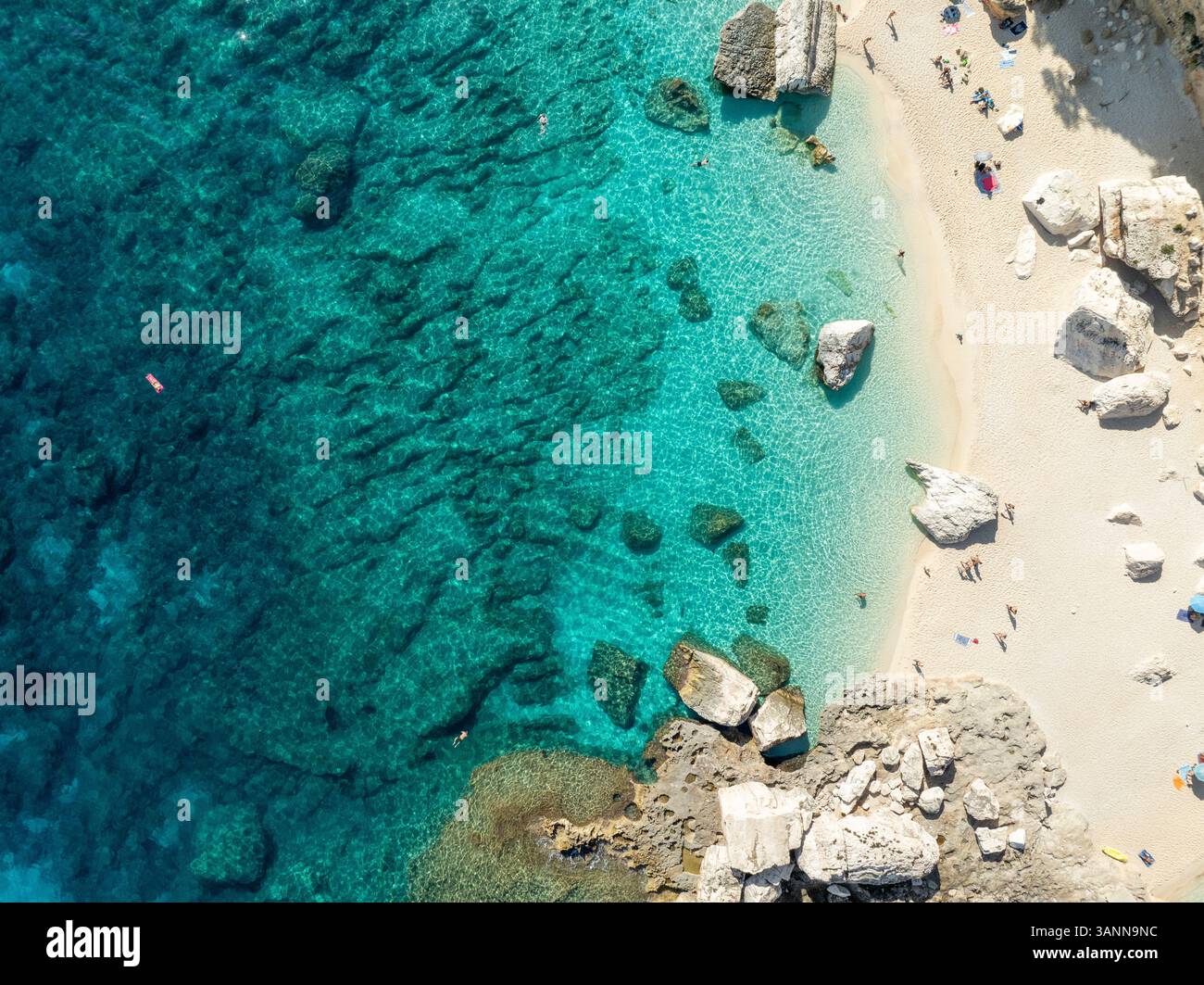 Aerial view of mariolu beach with a woman on an inflatable mattress ...