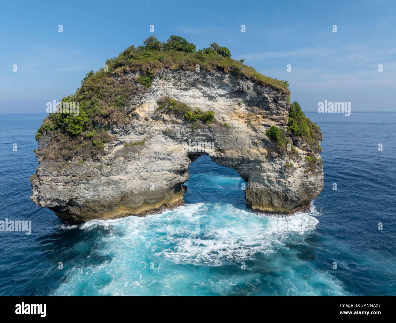 Aerial view of beautiful natural arch and rock formation by the serene ...