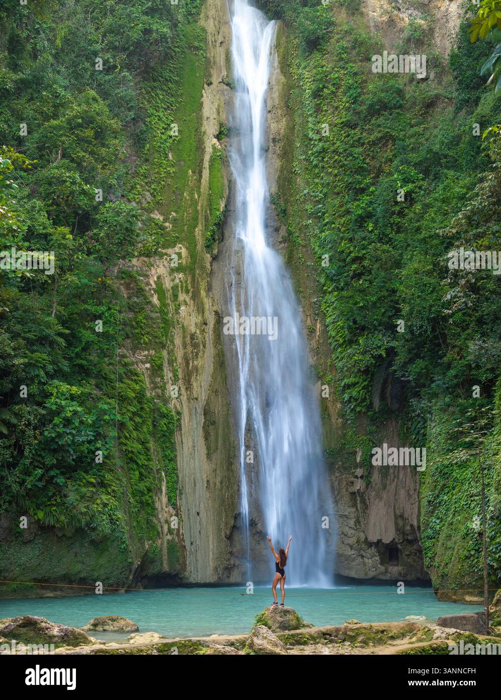 Aerial view of majestic mantayupan falls with a woman standing on a ...
