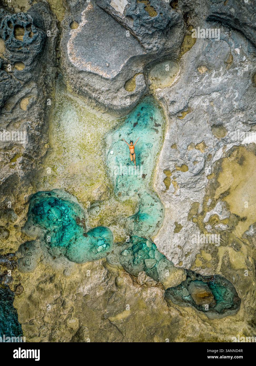 Aerial view of queen bath rock pool with a woman swimming in tranquil ...