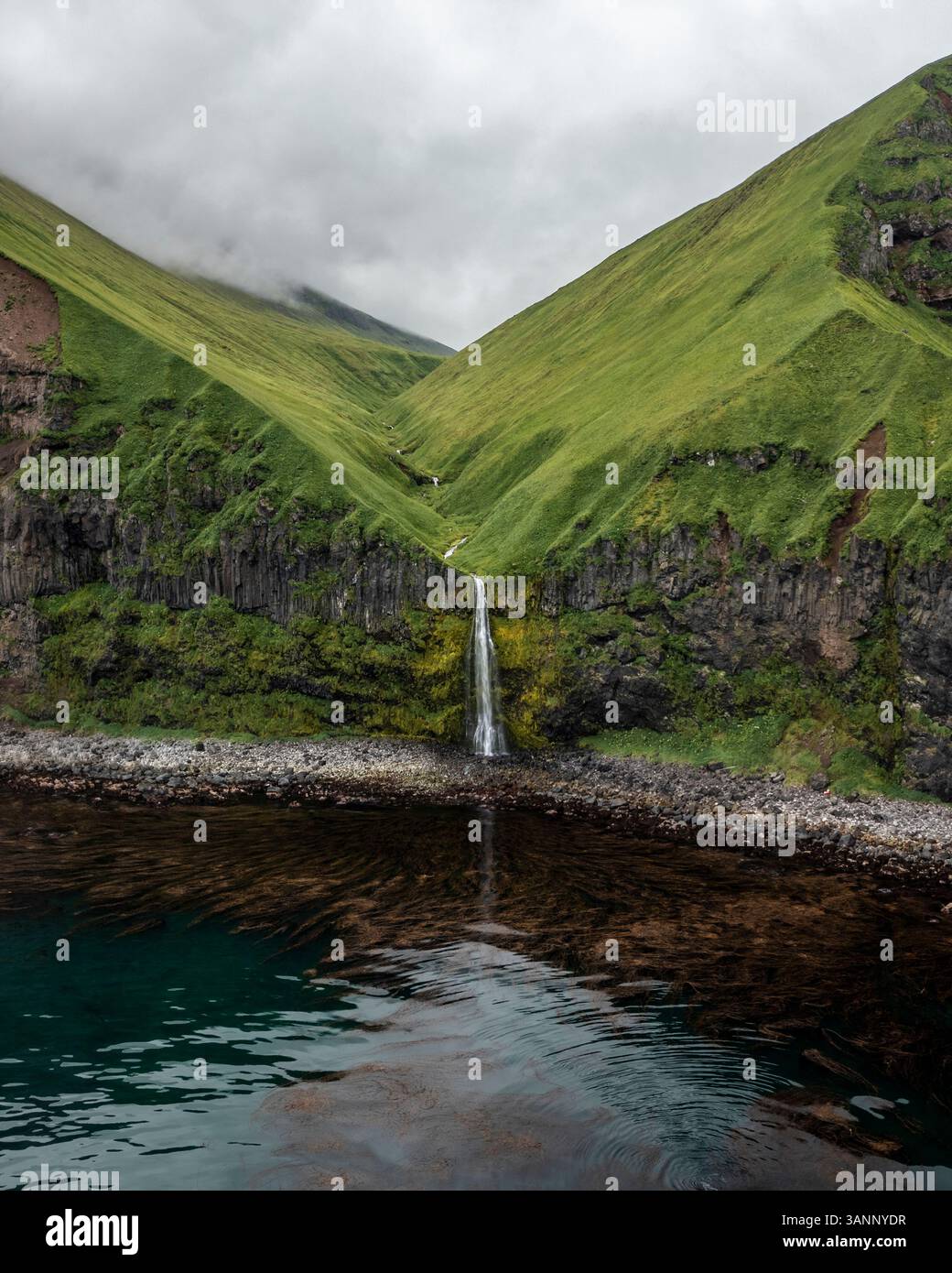 Aerial view of a waterfall along the coast, Driftwood Bay, Unalaska ...
