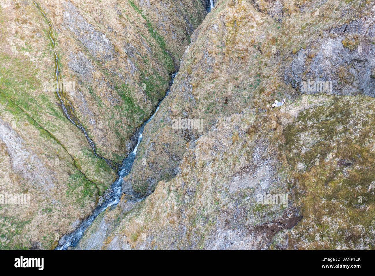 Aerial view of a small river streaming along the mountain on Unalaska ...