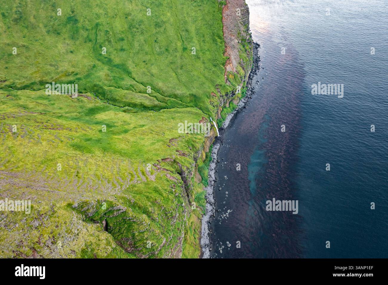 Aerial view of a waterfall along the coast, Driftwood Bay, Unalaska ...