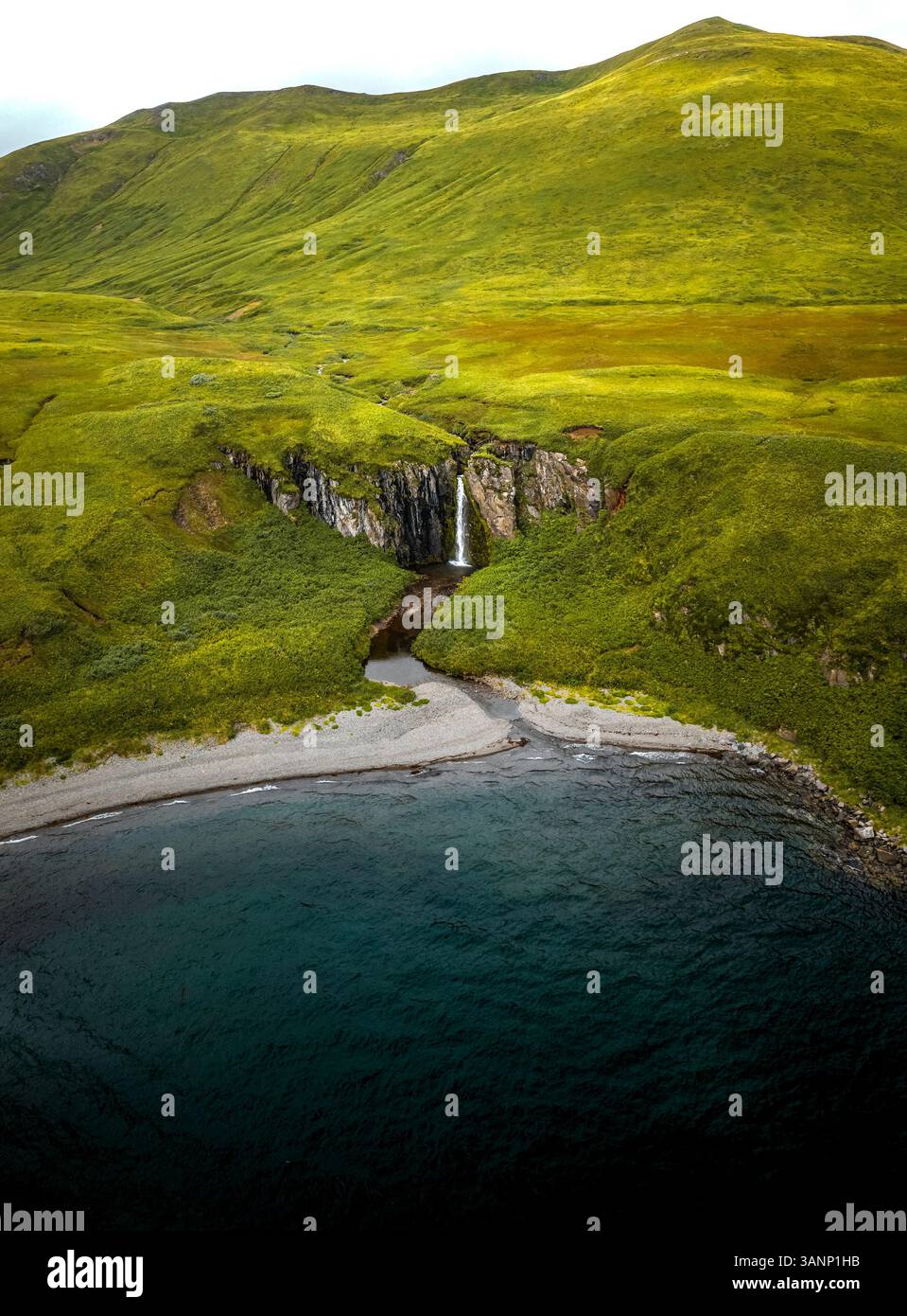 Aerial view of a waterfall along the coast in Broad Bay, Unalaska ...
