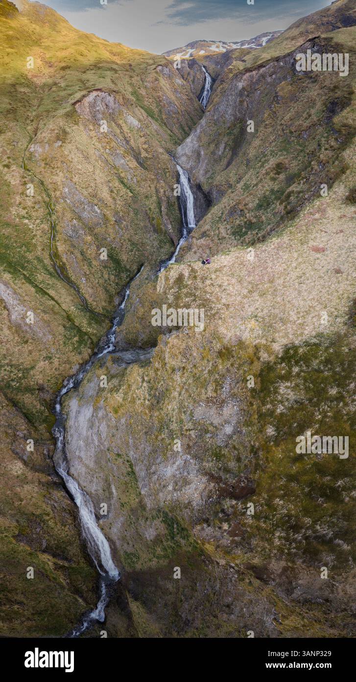 Aerial view of a small river streaming along the mountain on Unalaska ...