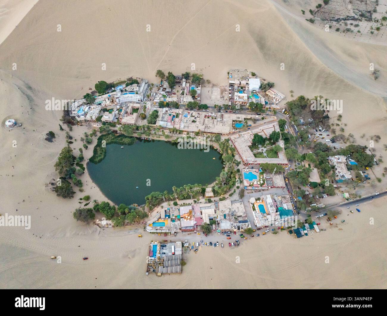 Aerial close up of Huacachina desert oasis resorts and swimming pools ...