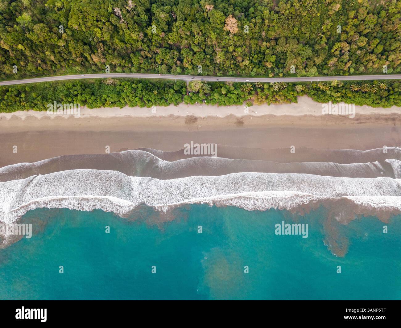 Aerial view of long road in forest by beach and ocean, Puntarenas ...