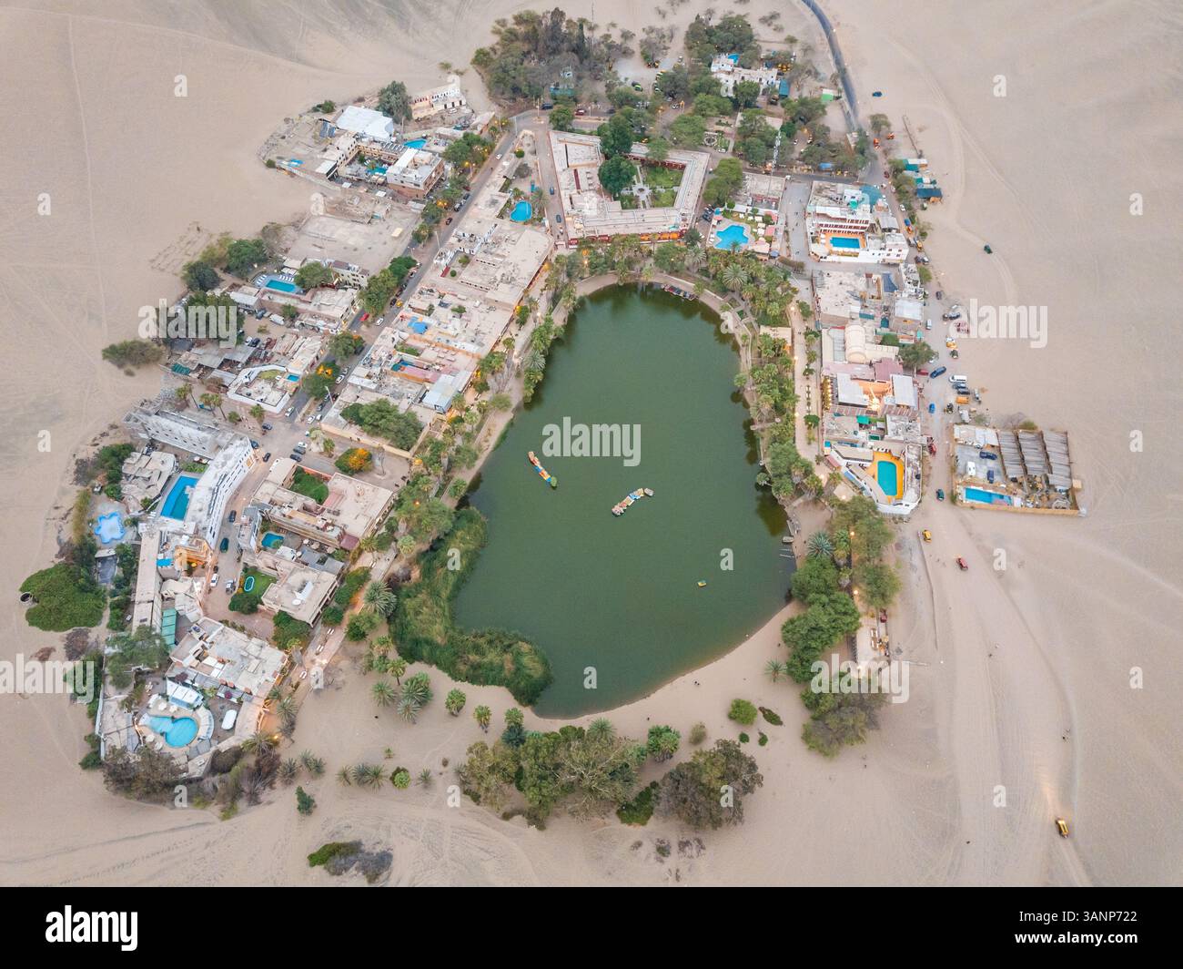 Aerial close up of Huacachina desert oasis resorts and swimming pools ...