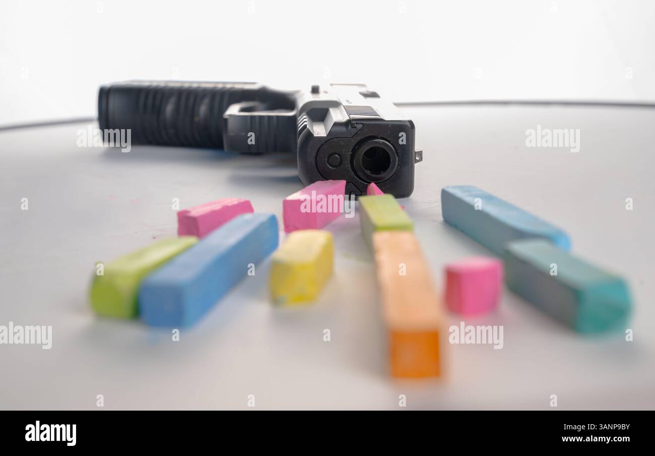 A striking image of a gun with bright chalk sticks, symbolizing the ...