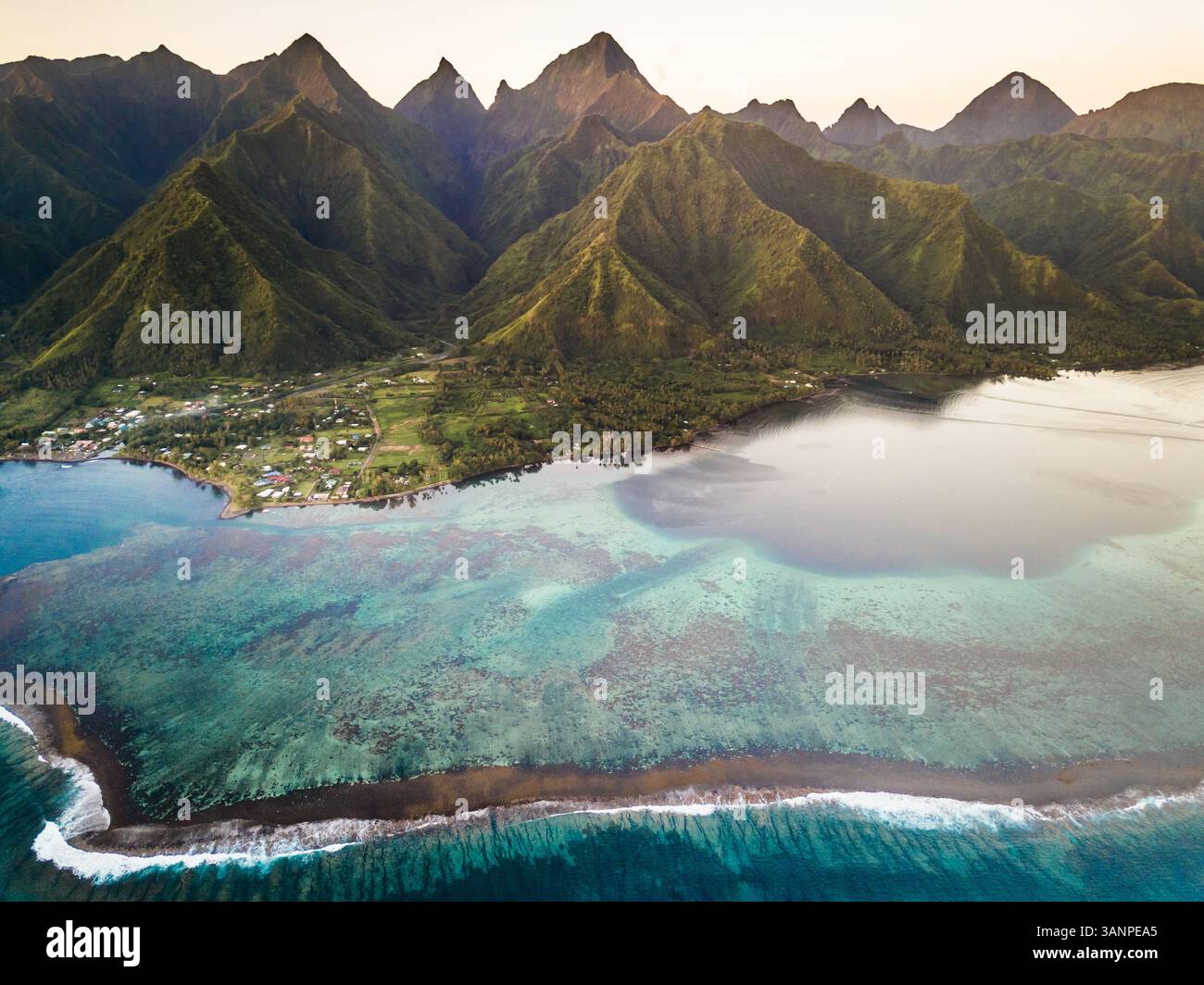 Aerial view of coral reef with The Mighty Mount Aorai in the background ...
