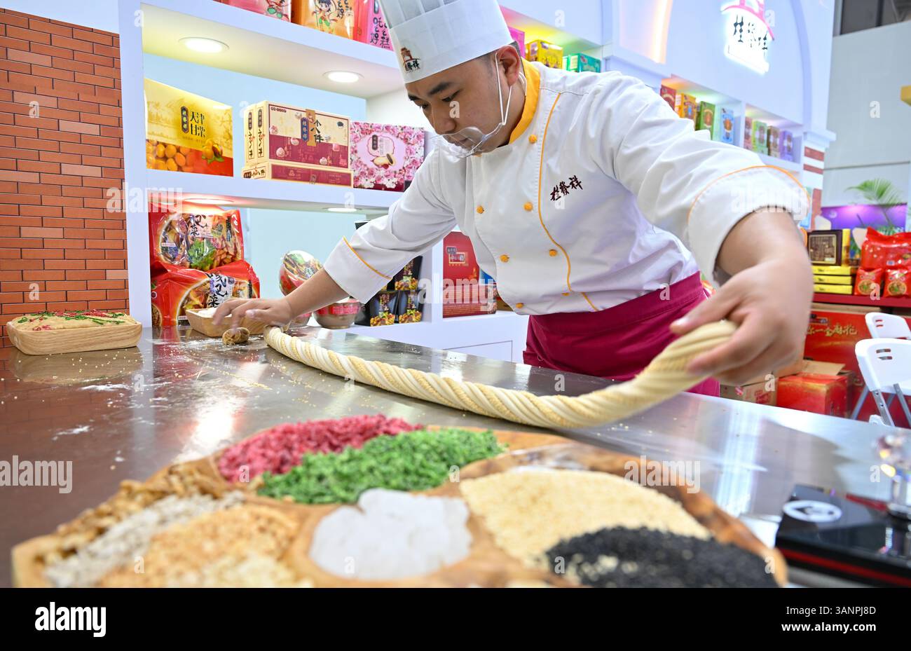(250415) -- HAIKOU, April 15, 2025 (Xinhua) -- A chef makes Guifaxiang 18th Street Mahua, a ...