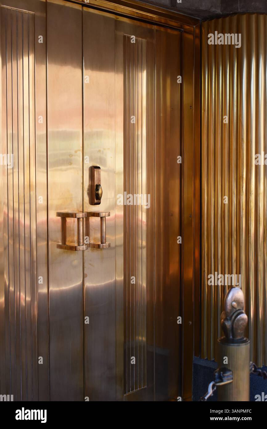 Golden metal door with a handle in the interior of a restaurant. A ...