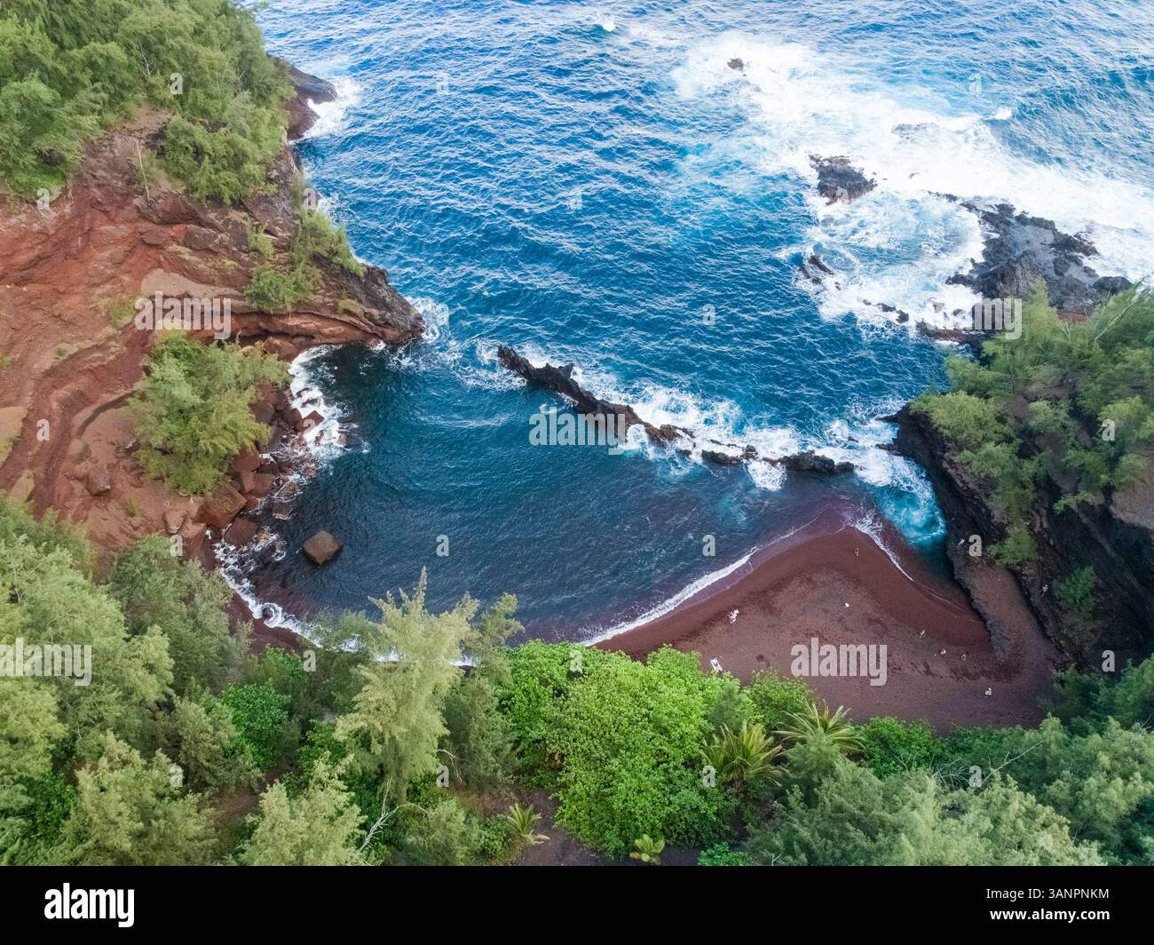 Aerial view of hidden red sand beach surrounding by rainforest, Hawaii ...