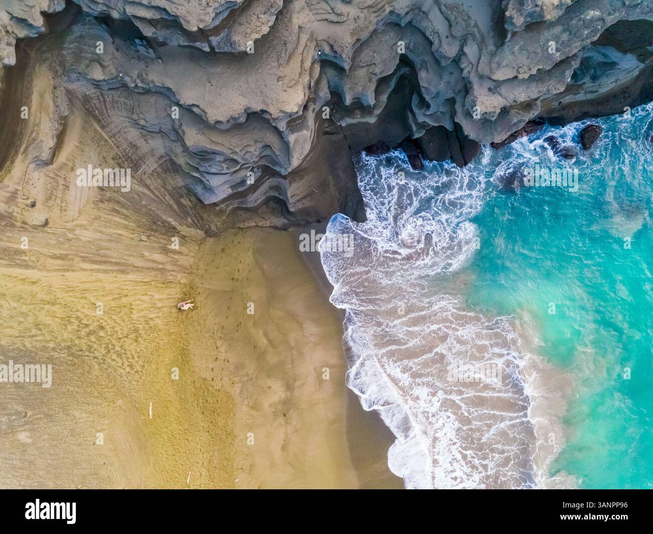 Aerial view of couple lay down on a green sand beach, Hawaii, U.S.A ...