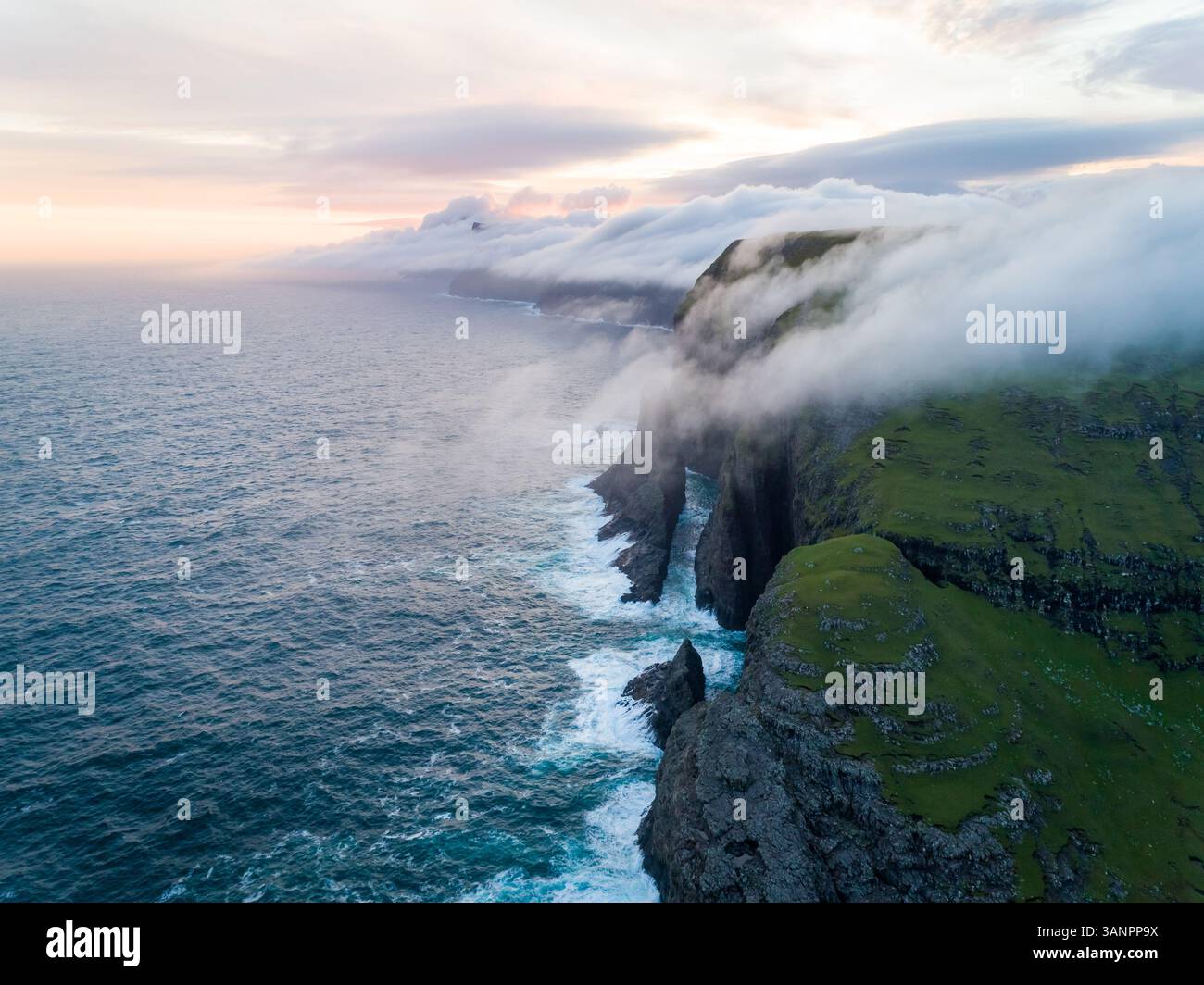 Scenic aerial view of a cliff on North Atlantic sea during the sunset ...
