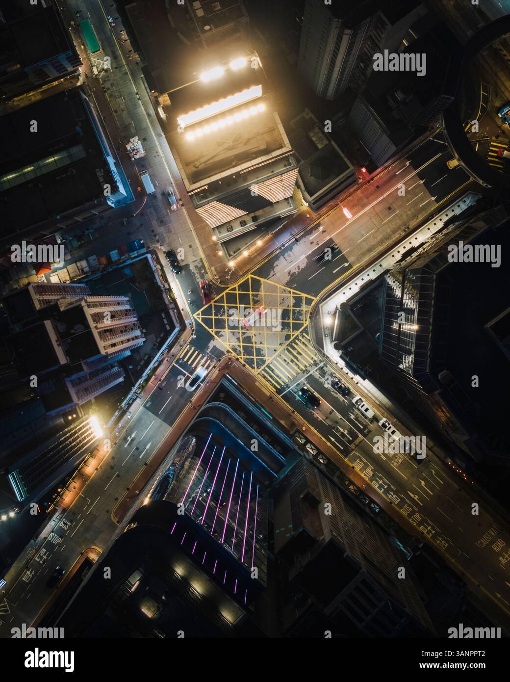 Aerial view of vehicles driving a road intersection at night in Hong ...