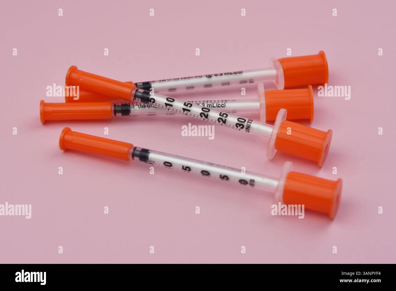 Close up of plastic medical syringes on pastel pink background, sterile ...