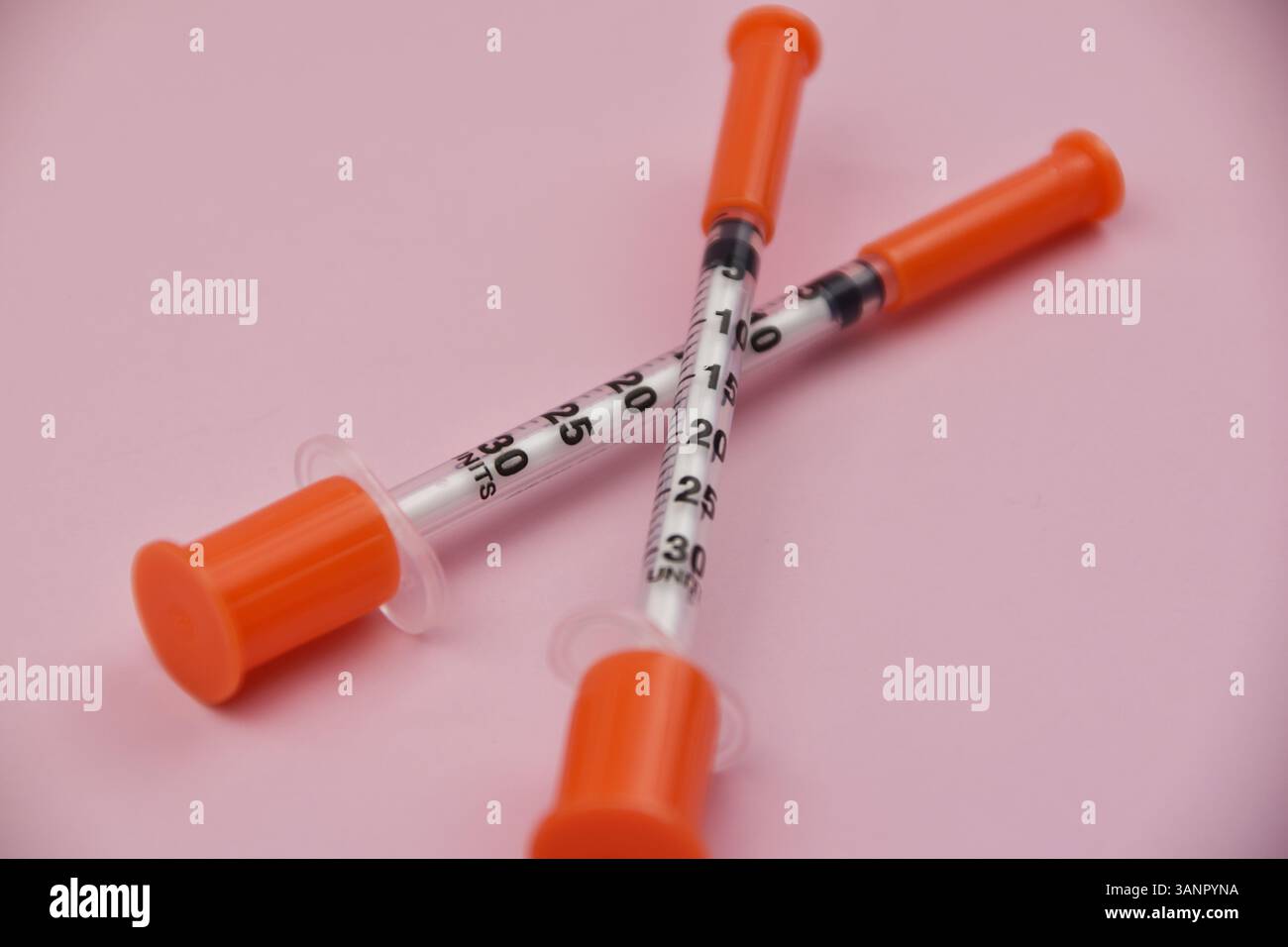 Macro view of disposable syringes for injection on clean pink ...