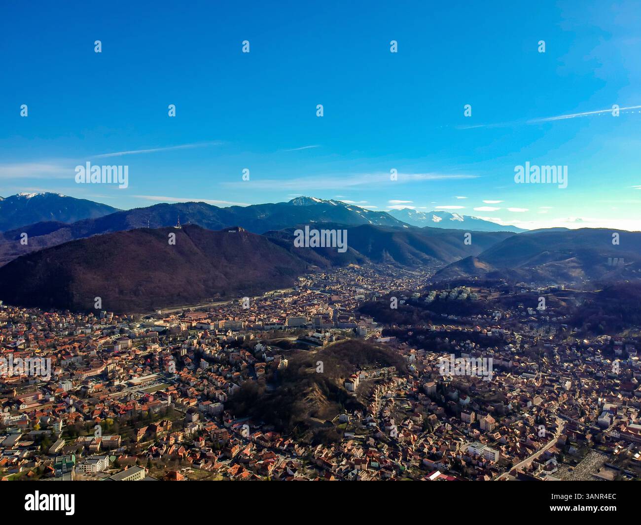 Aerial view of Brasov City with the Bucegi mountain range in the ...