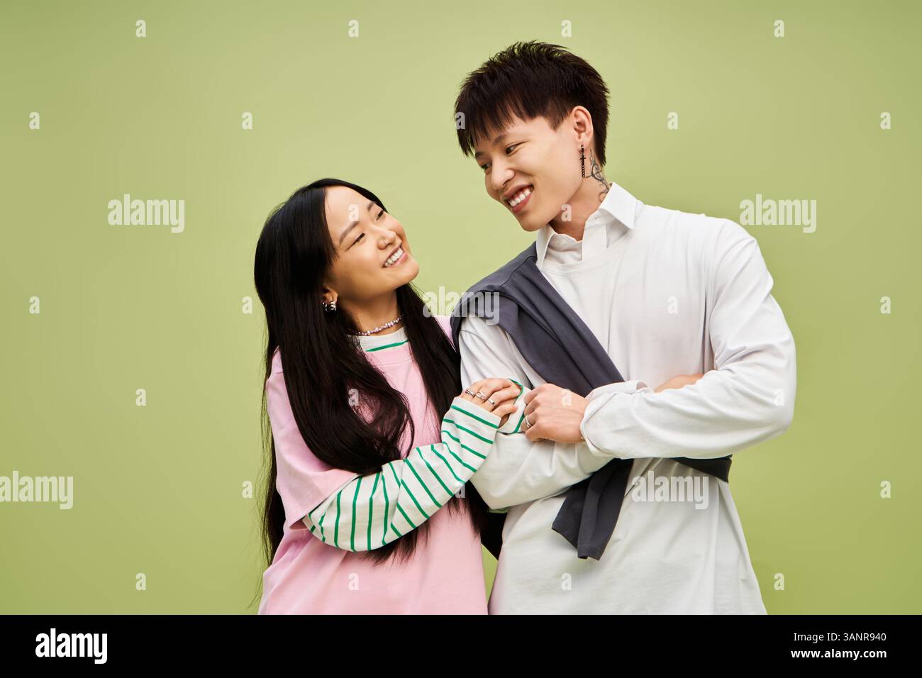 A couple shares a loving gaze while dressed fashionably, embracing each ...