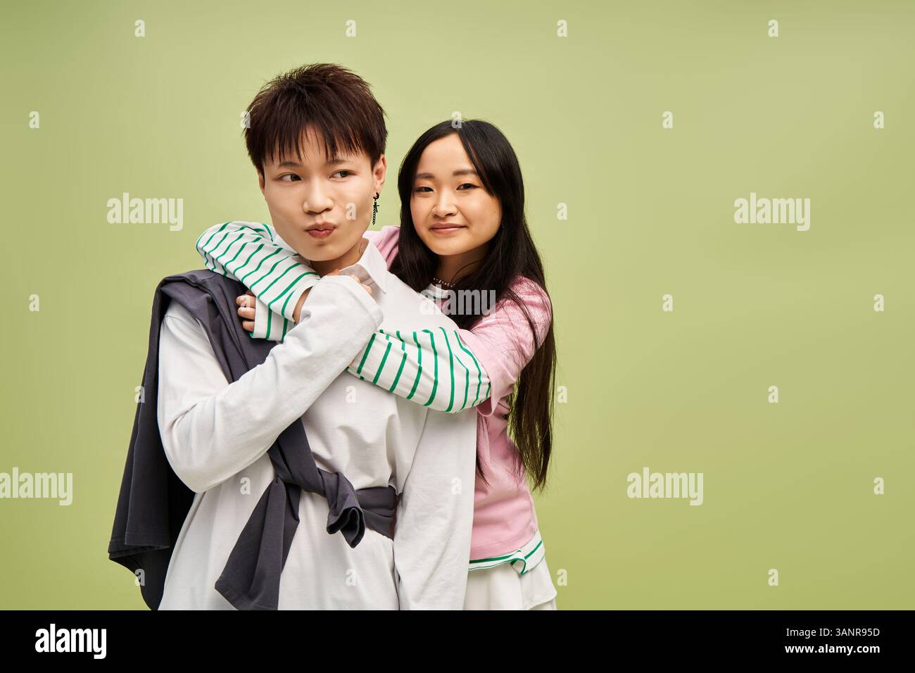 A stylish couple playfully poses in a warm embrace, showing their love ...
