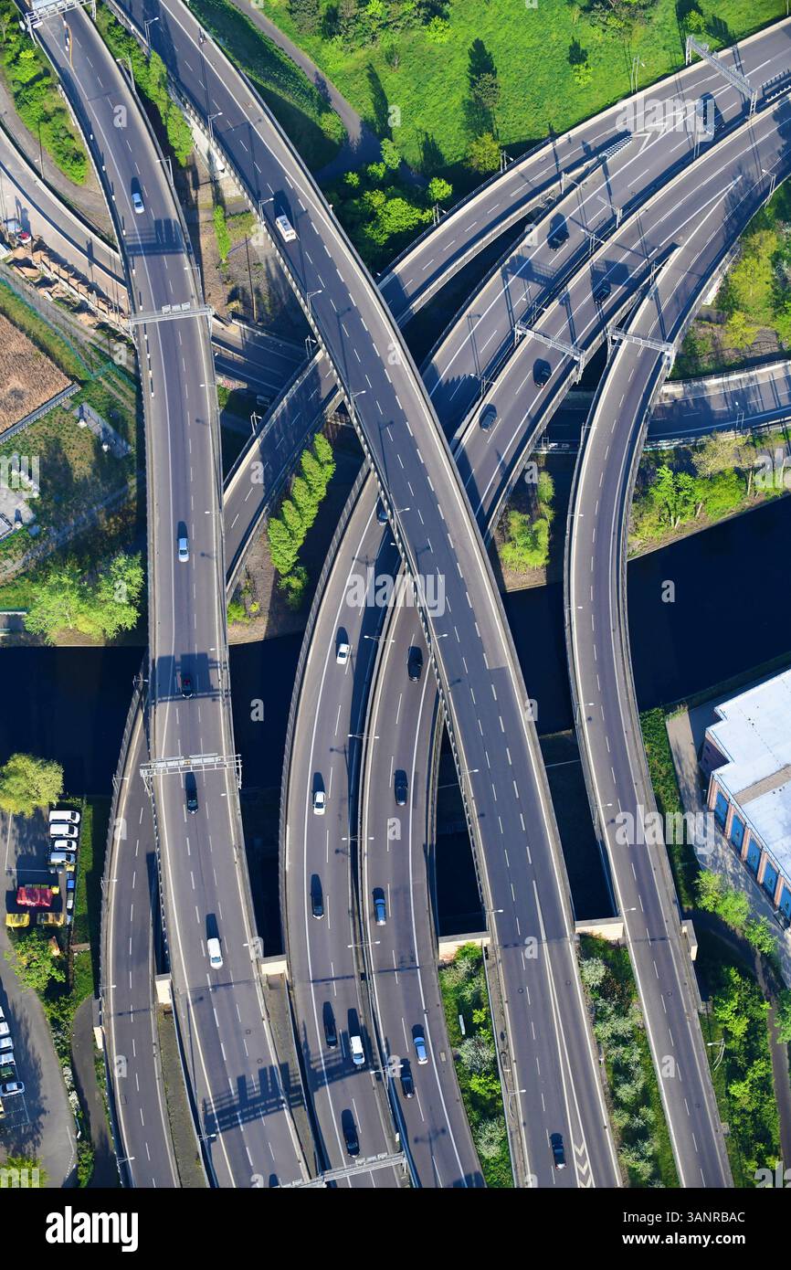 Aerial view of busy urban highway intersection with cars and greenery ...