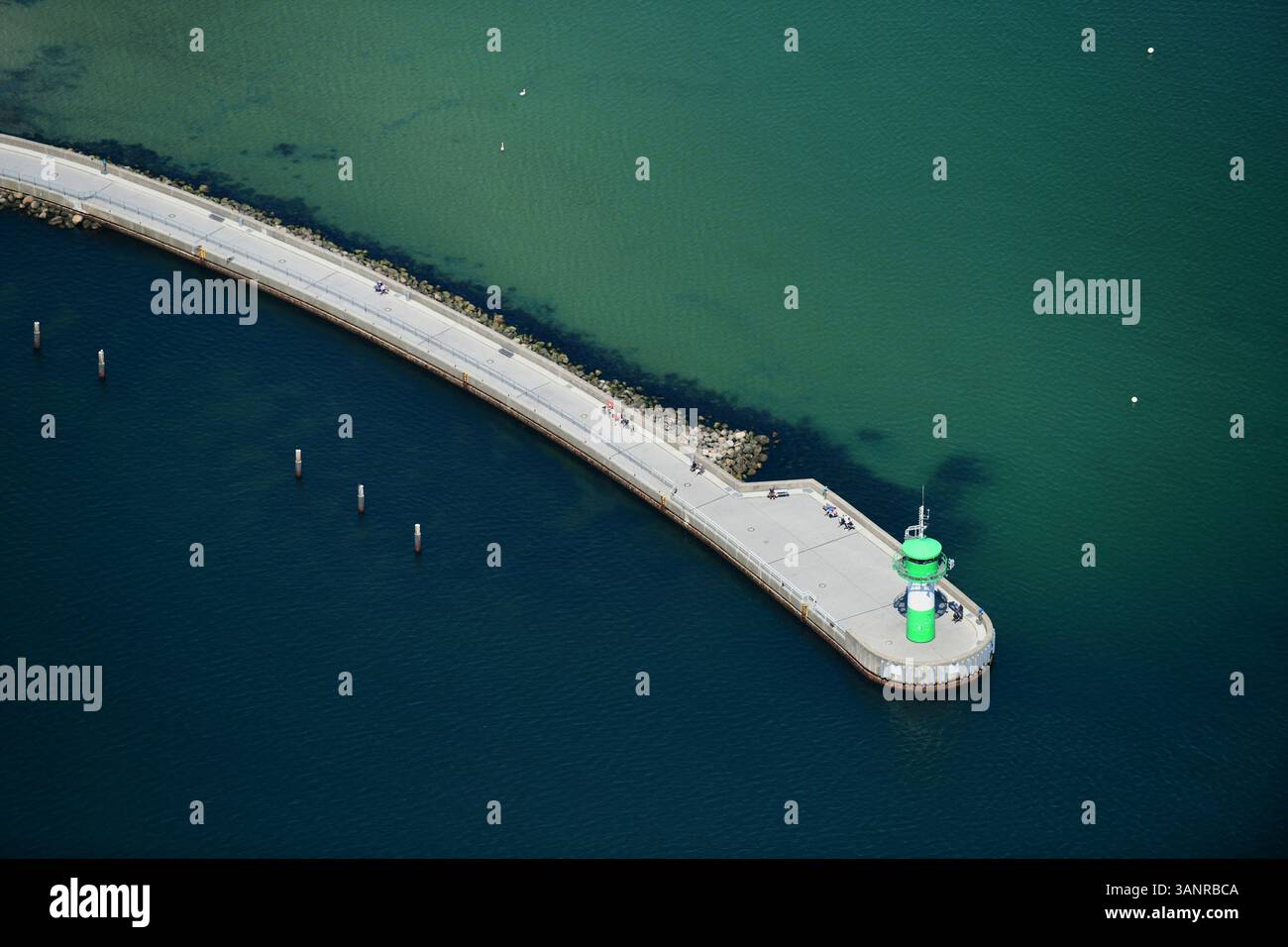 Aerial view of a scenic coastal harbor with a lighthouse and pier, Alt ...