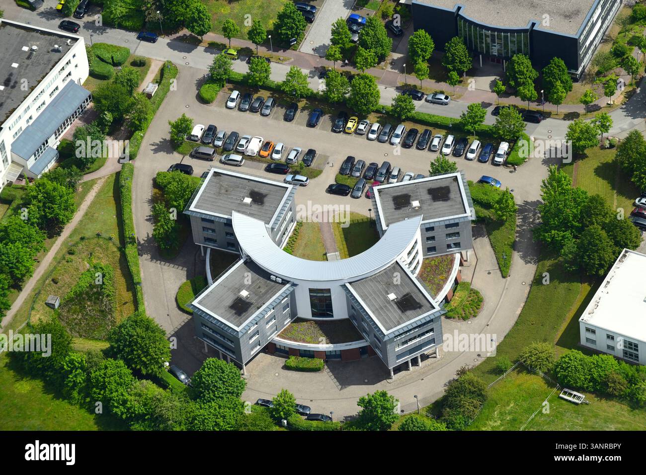 Aerial view of modern office building complex with parking lot, cars ...