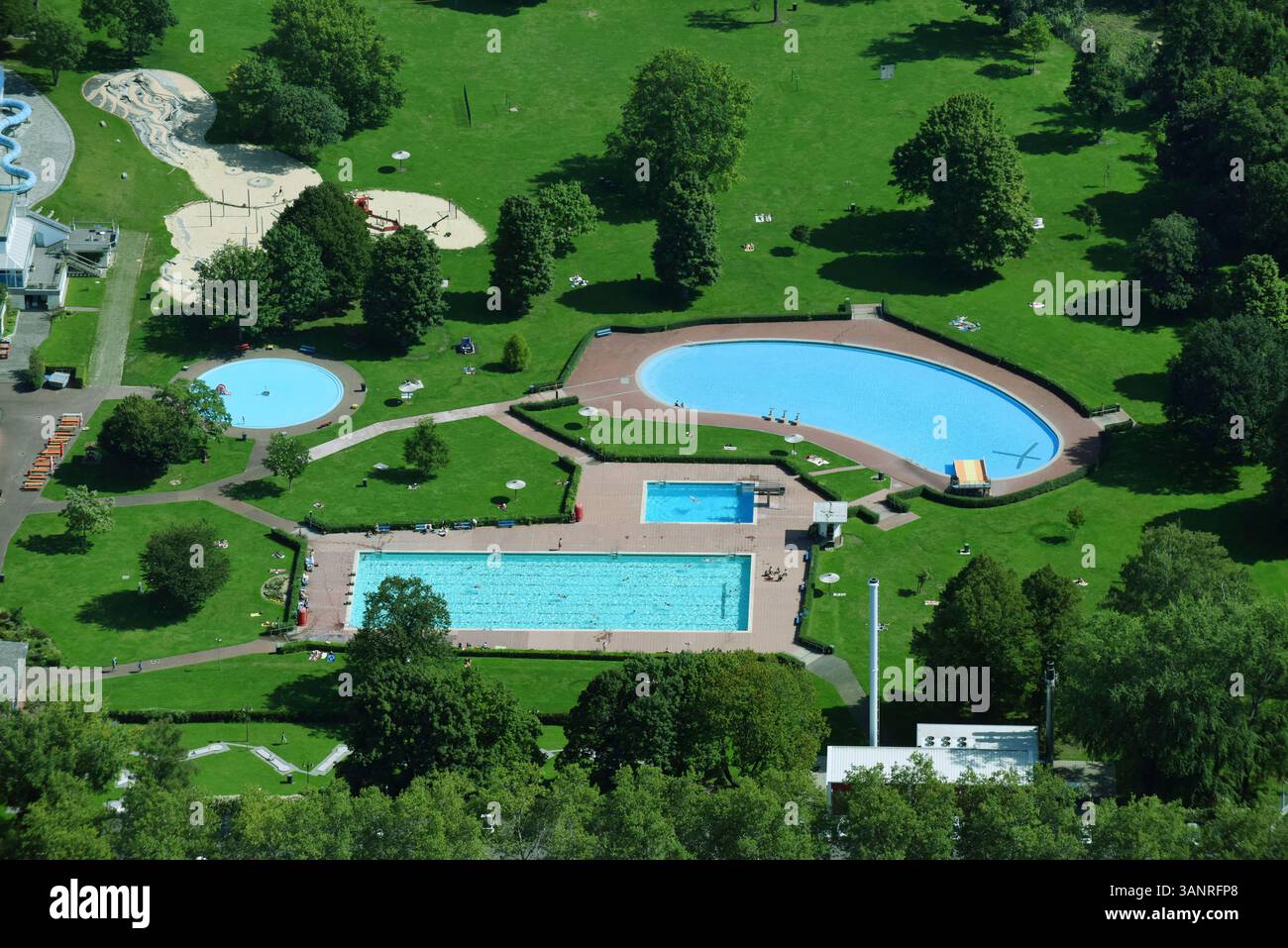 Aerial view of a beautiful outdoor swimming pool surrounded by greenery ...