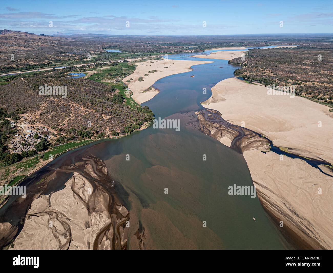 Aerial view of a beautiful river flowing through a dry and barren ...
