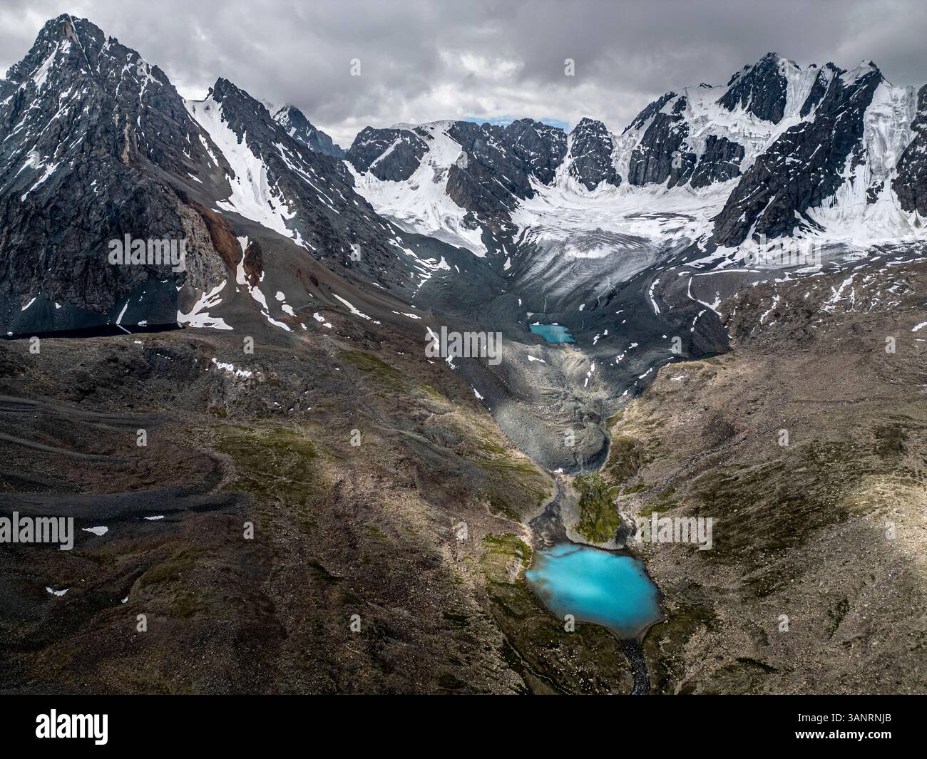 Aerial view of majestic snow-capped mountains and a pristine blue lake ...