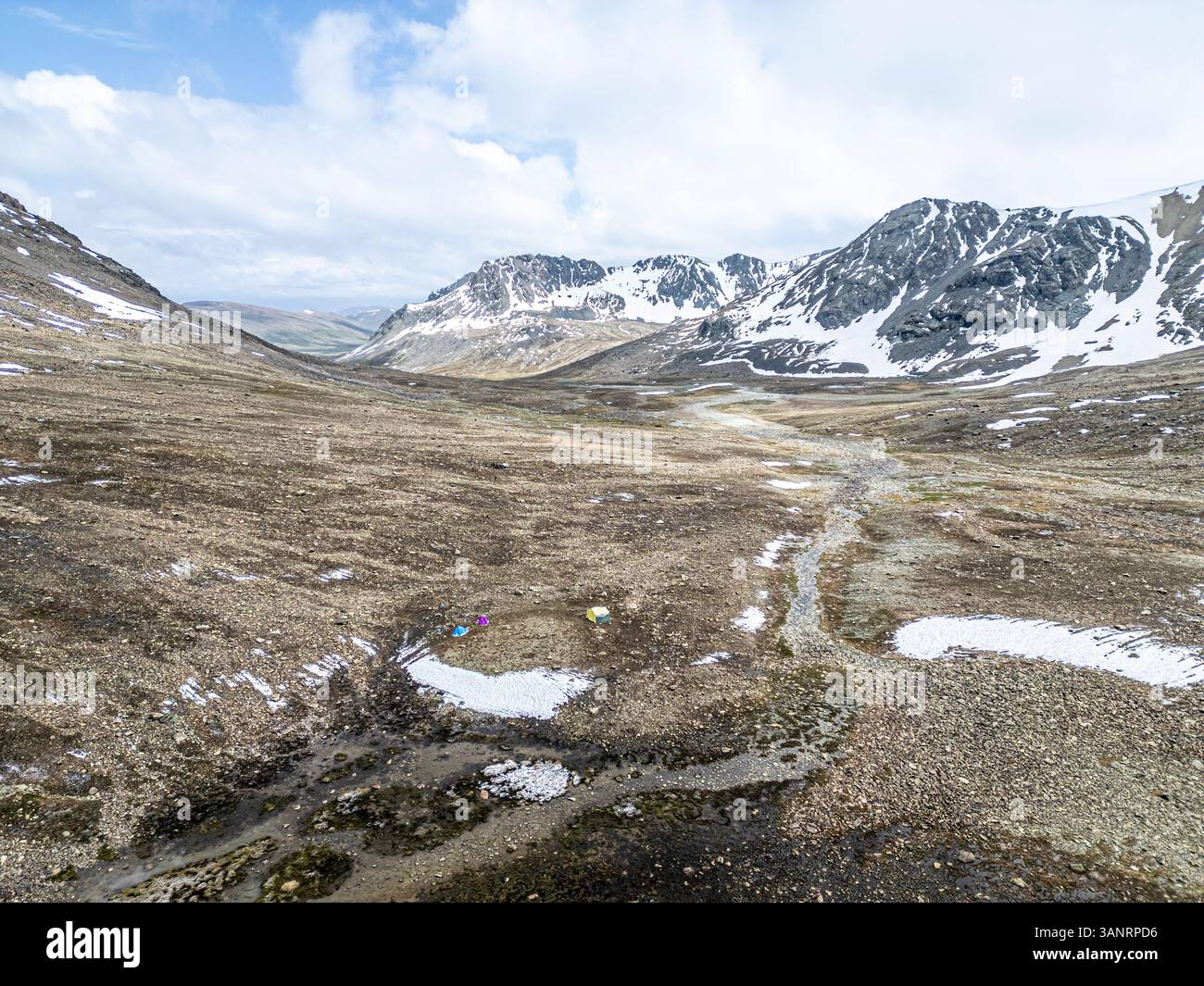 Aerial view of majestic snow-covered mountains and a vast valley in ...