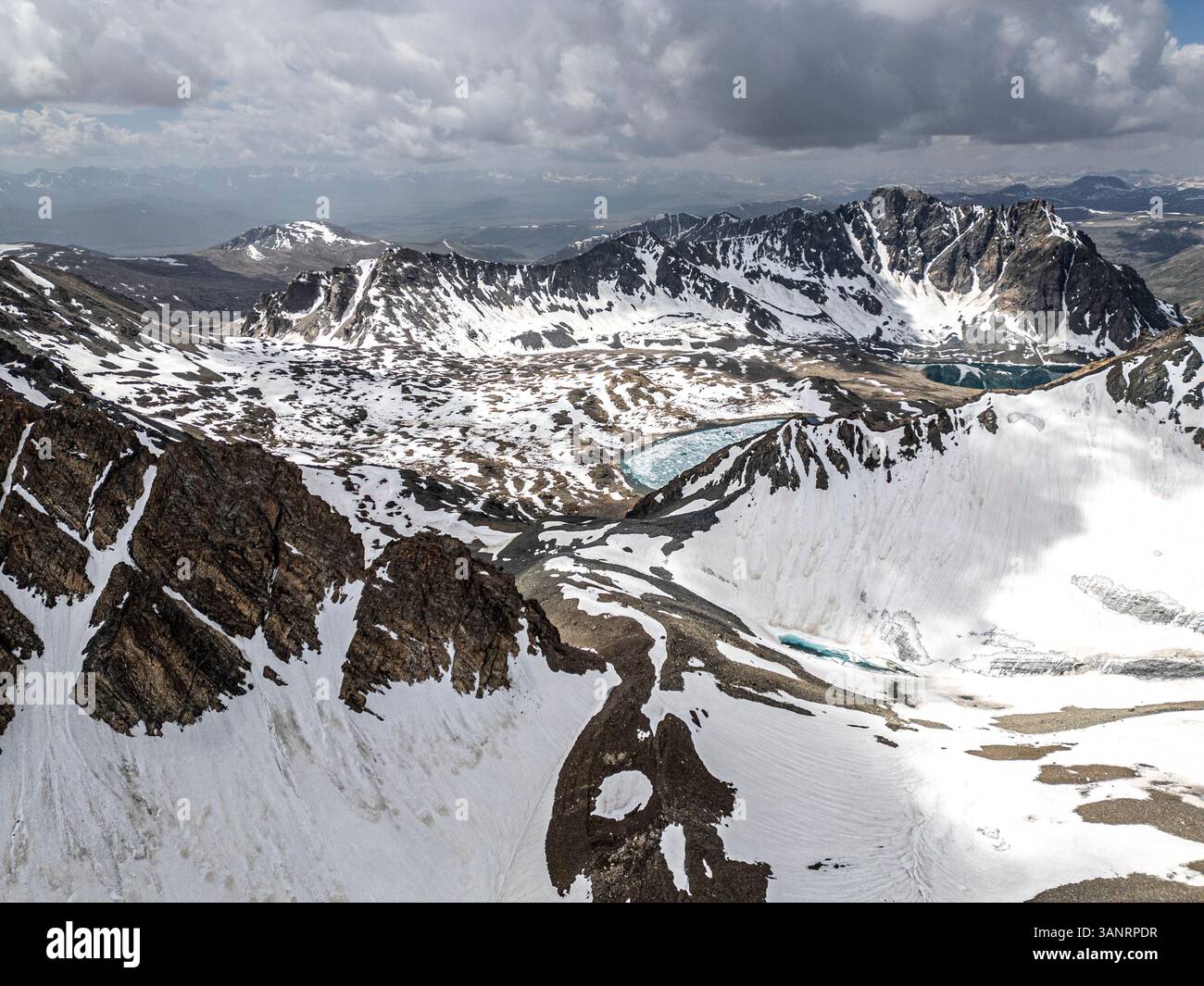 Aerial view of snowy mountains under a cloudy sky in Deosai National ...