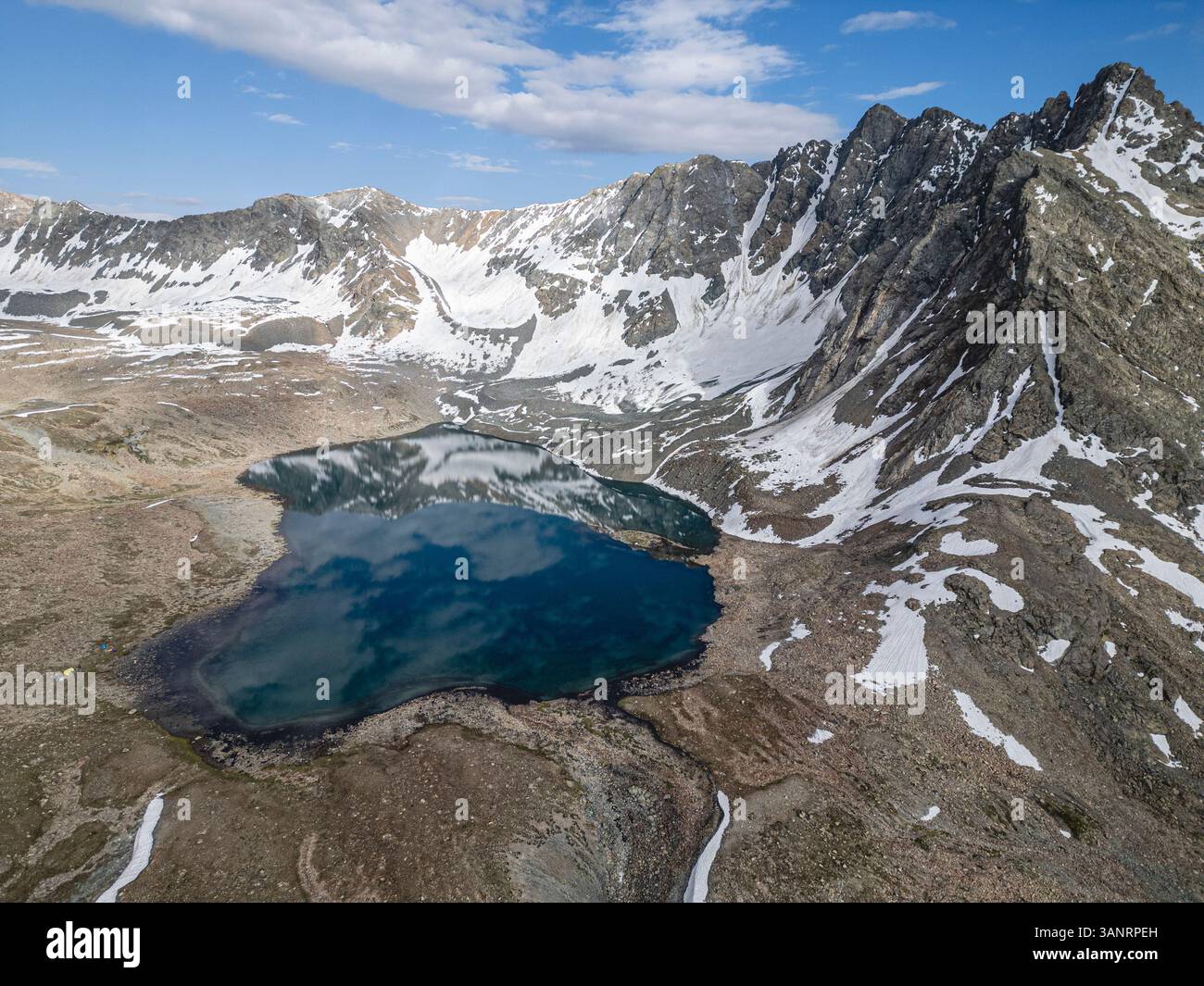 Aerial view of pristine snow-capped mountains surrounding a serene blue ...