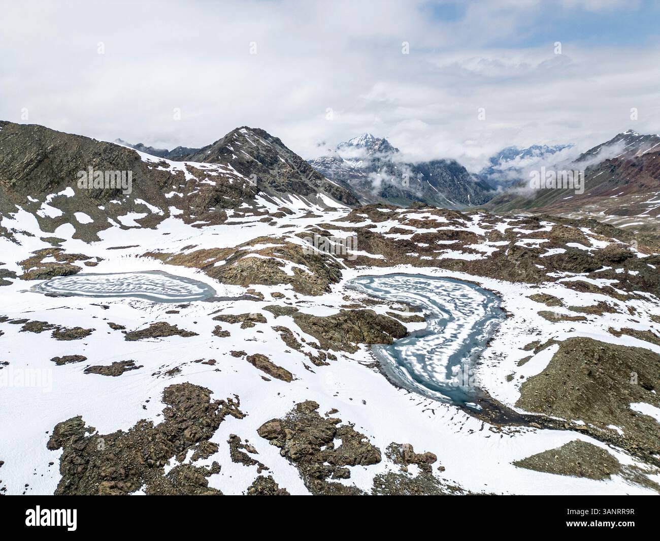Aerial view of majestic snow-covered mountains and a serene valley in ...