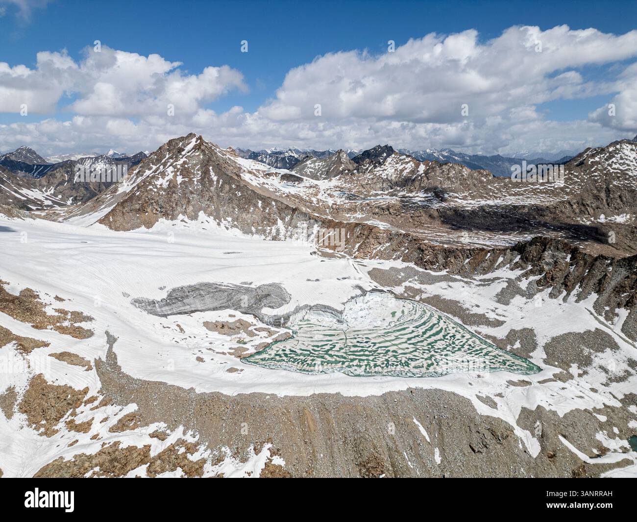 Aerial view of majestic mountains and glaciers under a serene sky ...