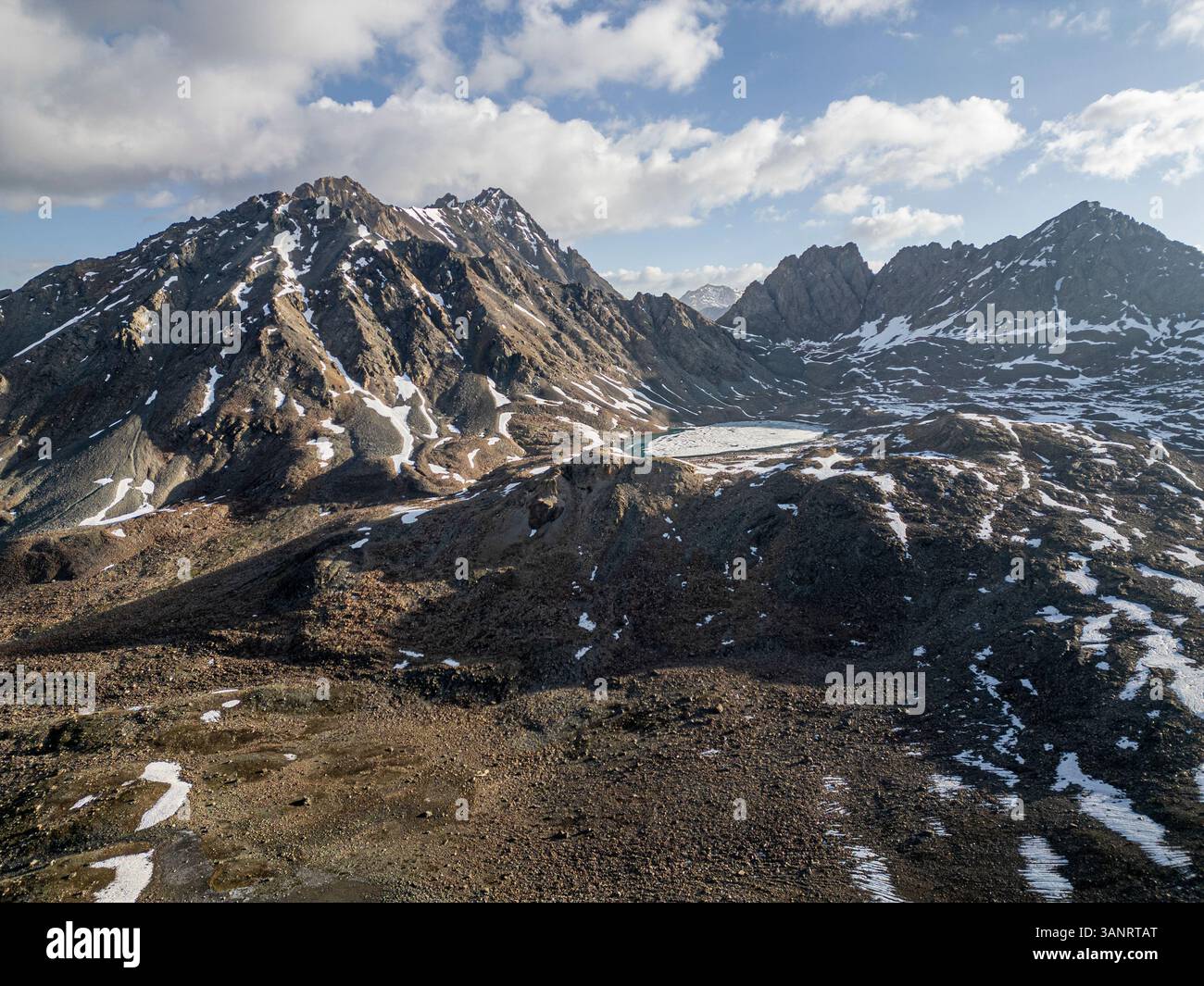 Aerial view of majestic snow-capped mountains under a dramatic sky with ...