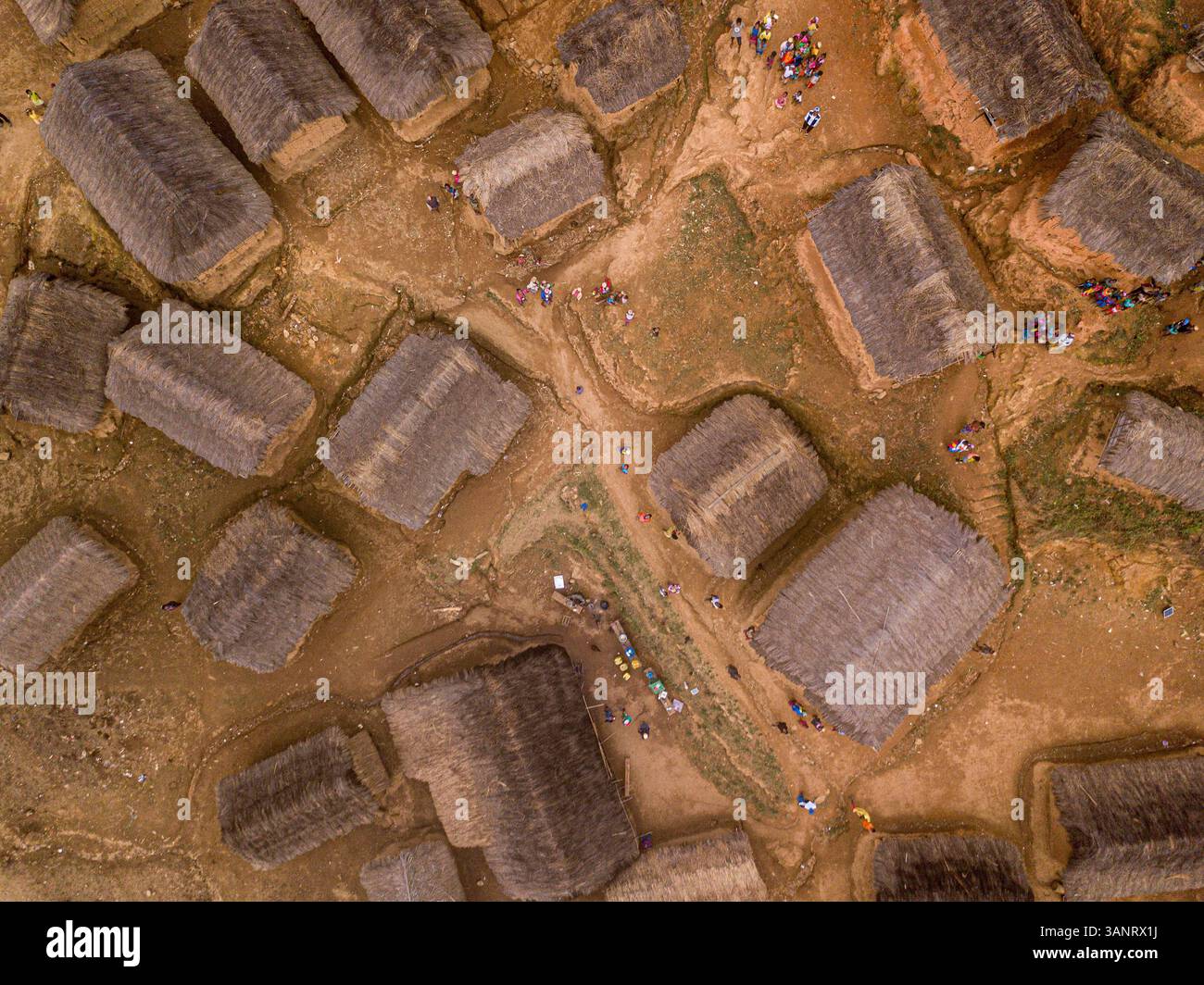 Aerial view of traditional village with thatched roofs and dirt paths, Ampasinambo village ...