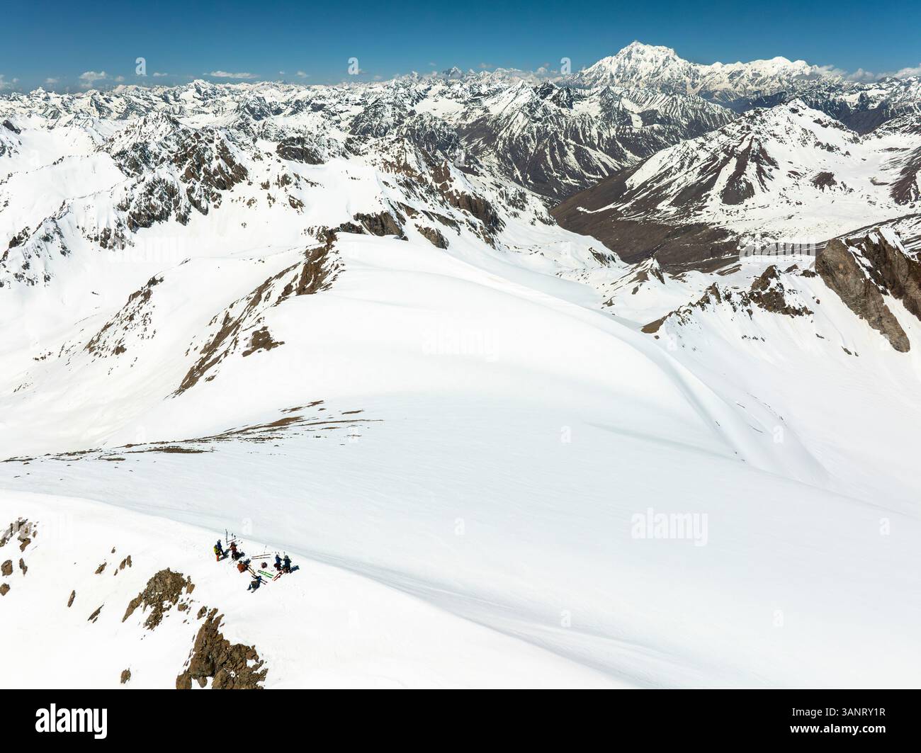 Aerial view of snow-covered Deosai National Park with skiers and Nanga ...