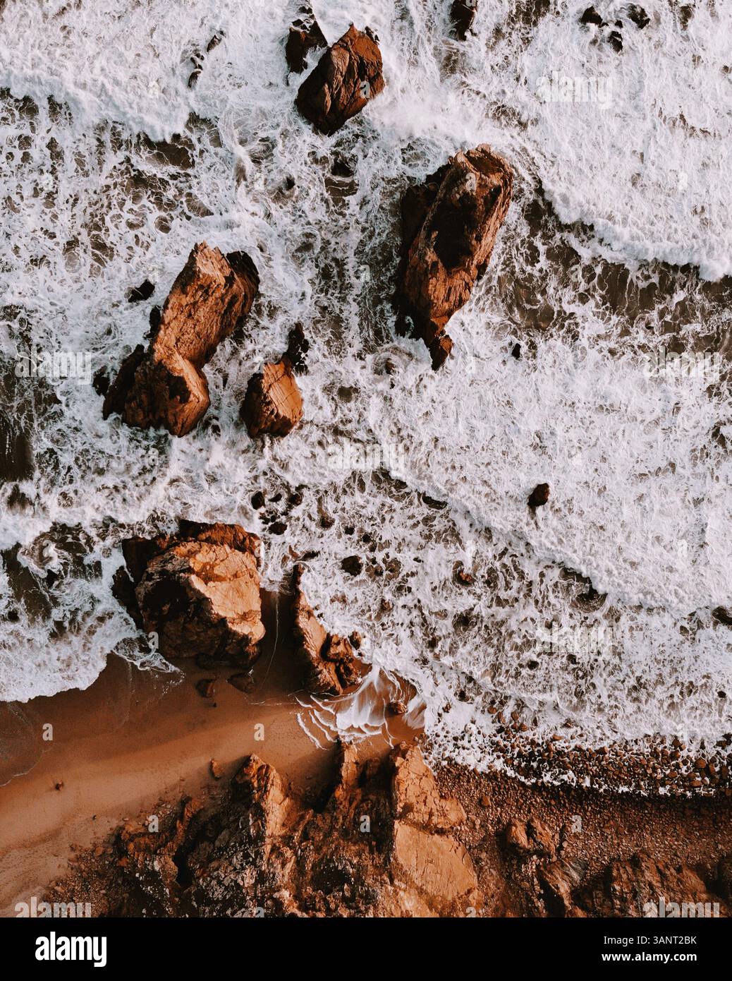 Aerial view of waves breaking on a coast with unique rock formation ...