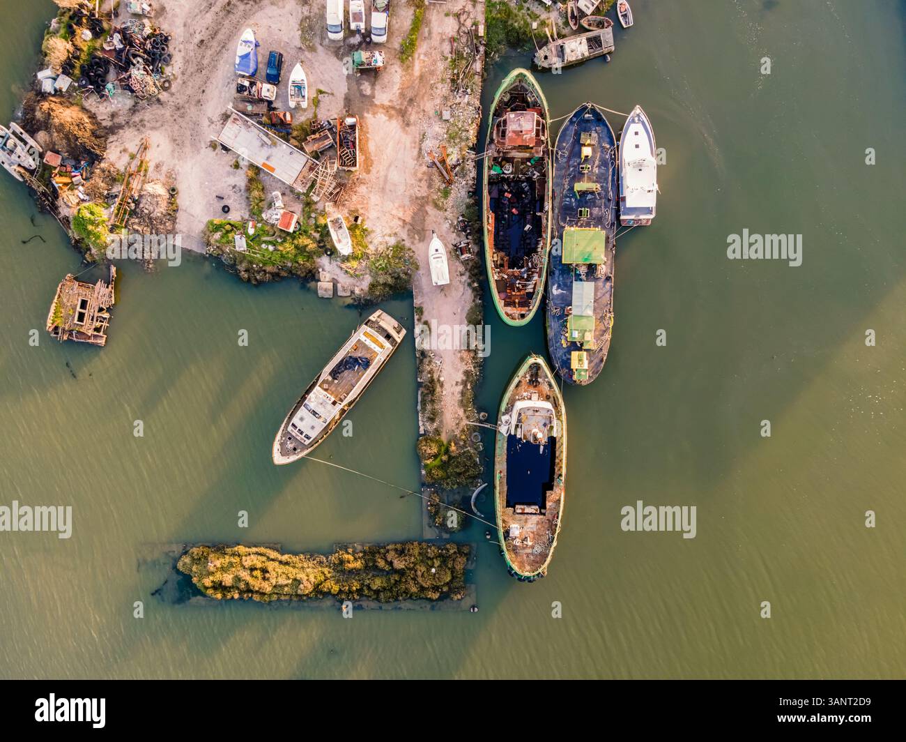 Aerial view of ships wrecks docked along a small shipyard harbour ...