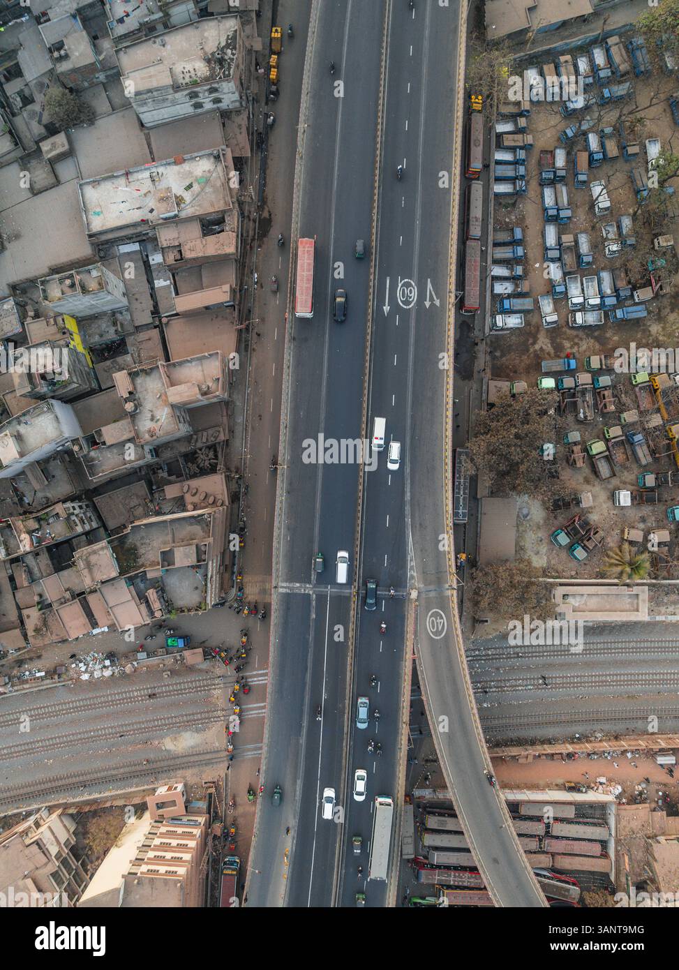 Aerial view of busy junction road with a bus station and railway tracks ...