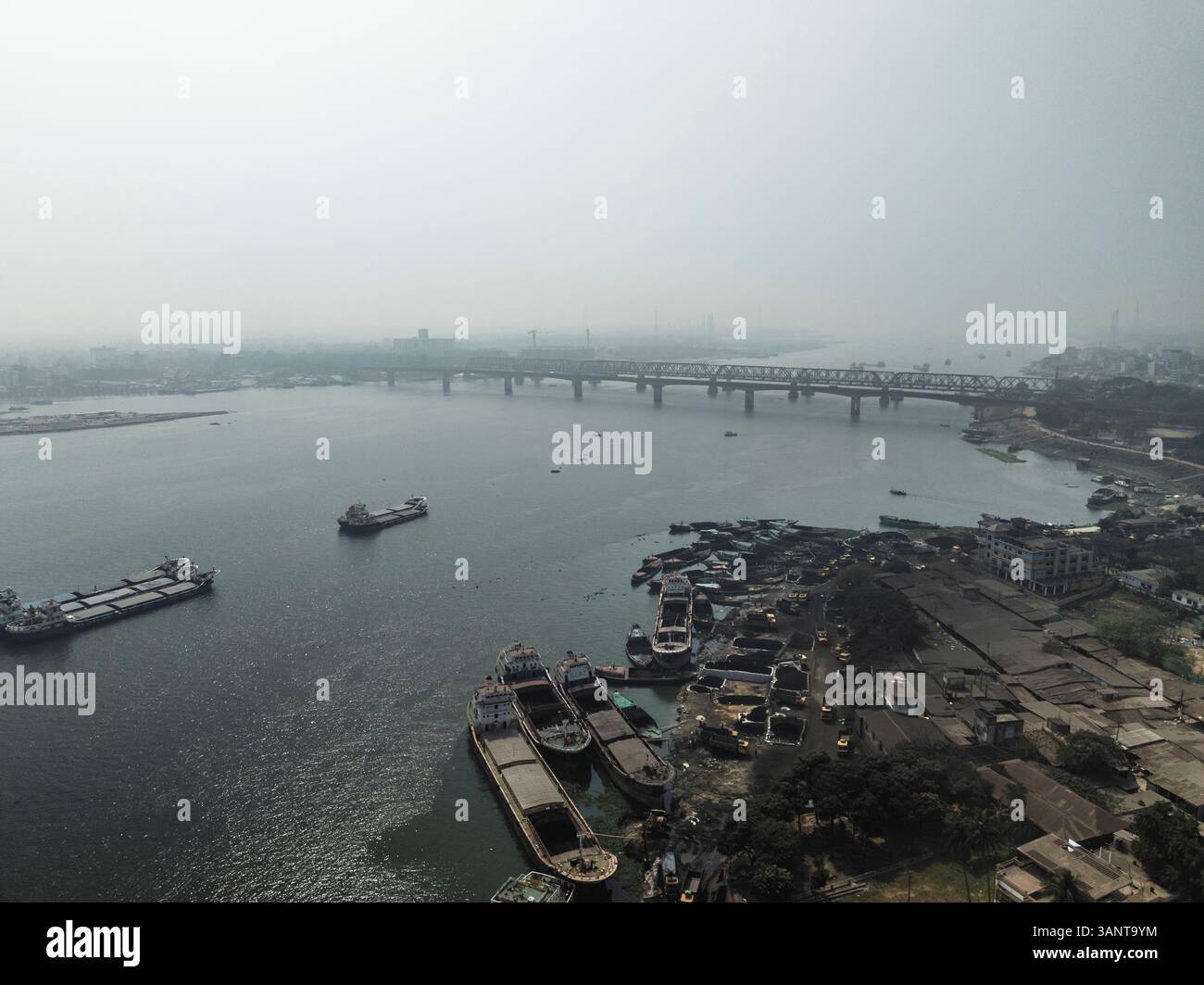 Aerial view of the Meghna River with an industrial coal factory, bridge ...