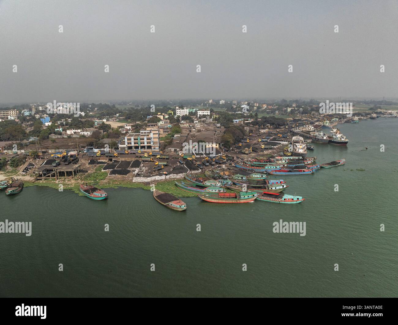 Aerial view of boats on the Meghna River with a backdrop of industrial ...