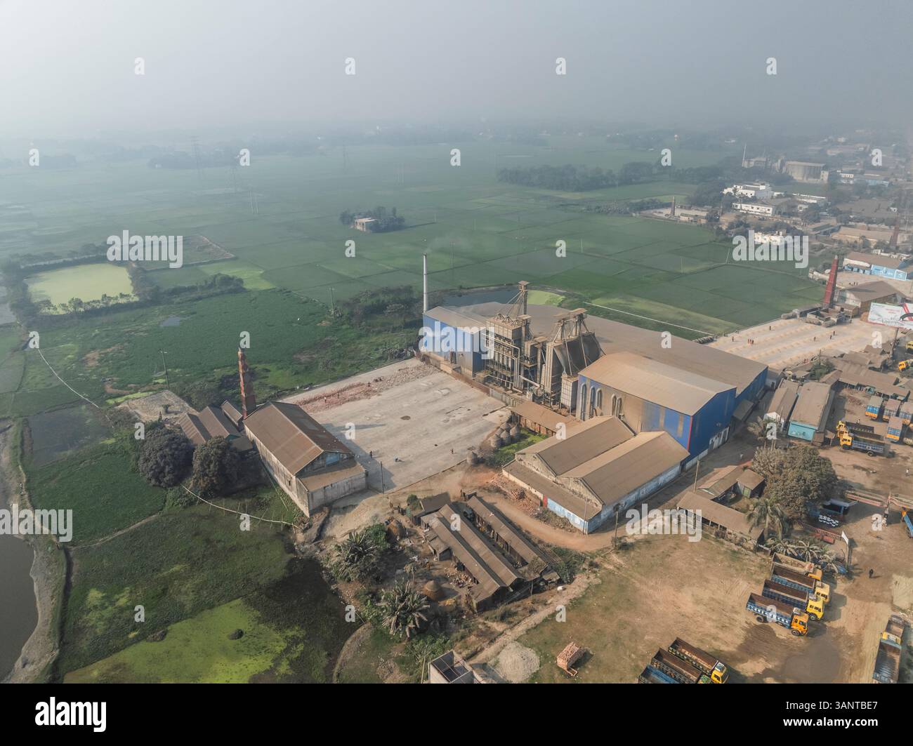 Aerial view of rice mills and lush rice fields in a rural landscape ...
