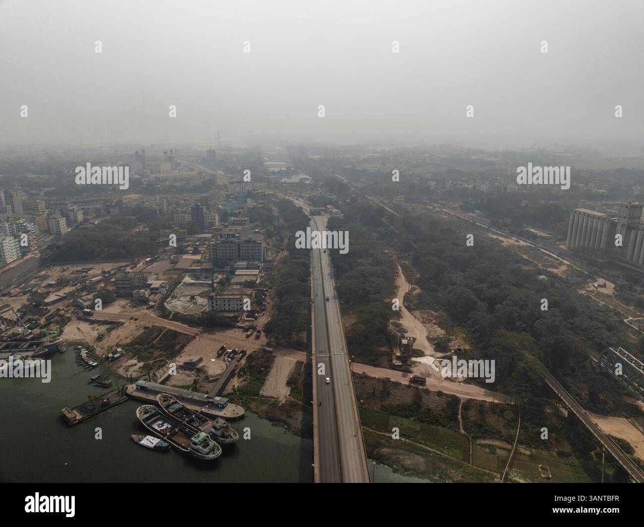 Aerial view of the Meghna River with a bridge and urban cityscape ...
