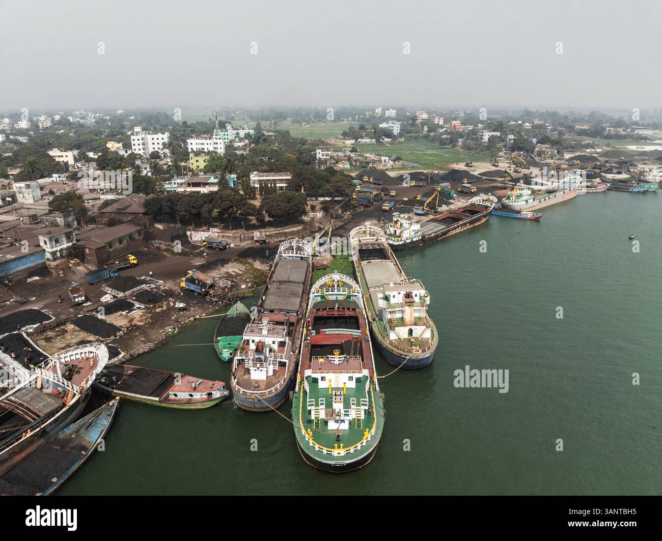 Aerial view of the Meghna River with industrial coal factory and bustling dock, Bhairab, Dhaka ...